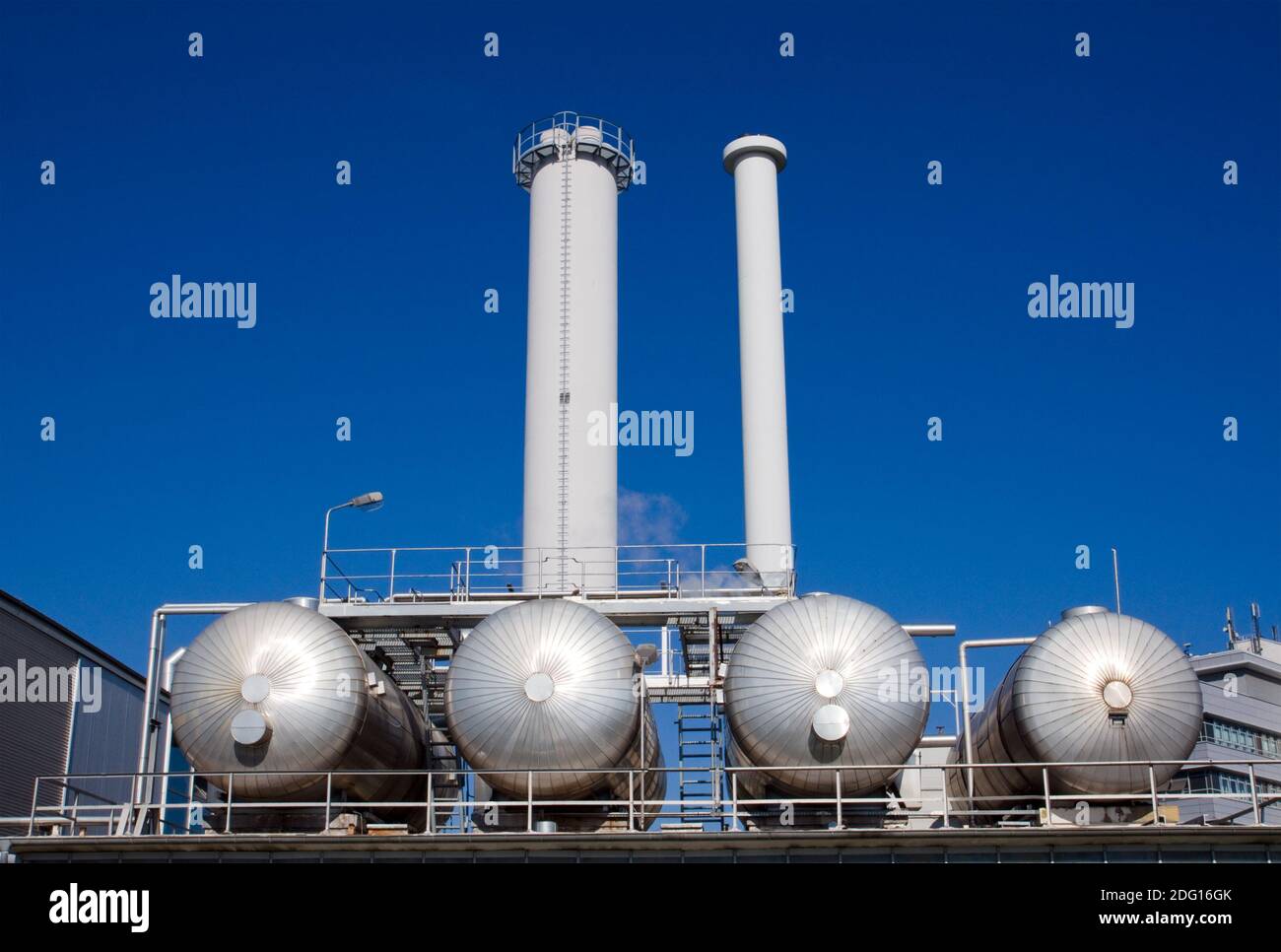 Silver tanks with smokestacks Stock Photo - Alamy