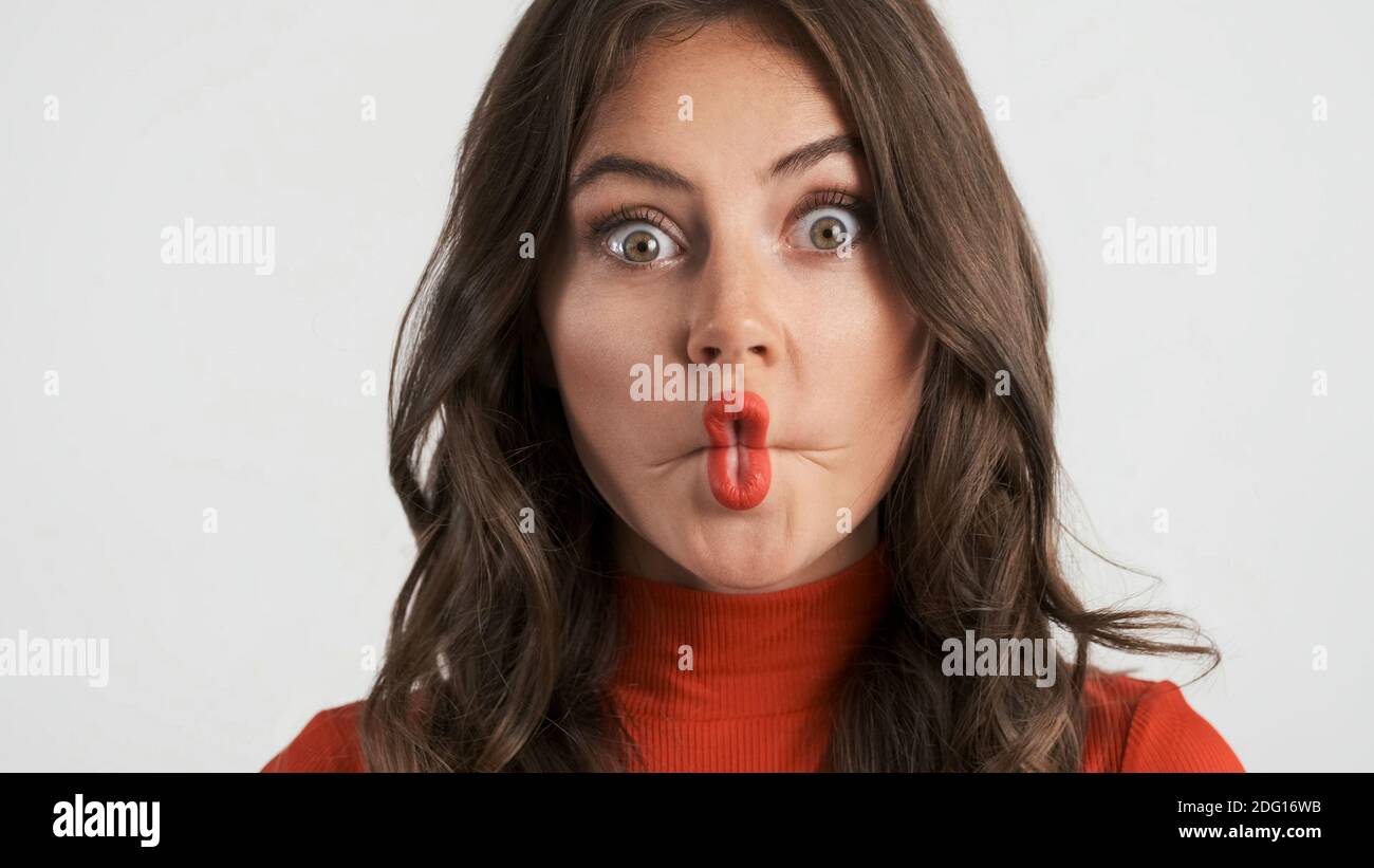 Portrait Of Pretty Girl Fooling Around On Camera Over White Background