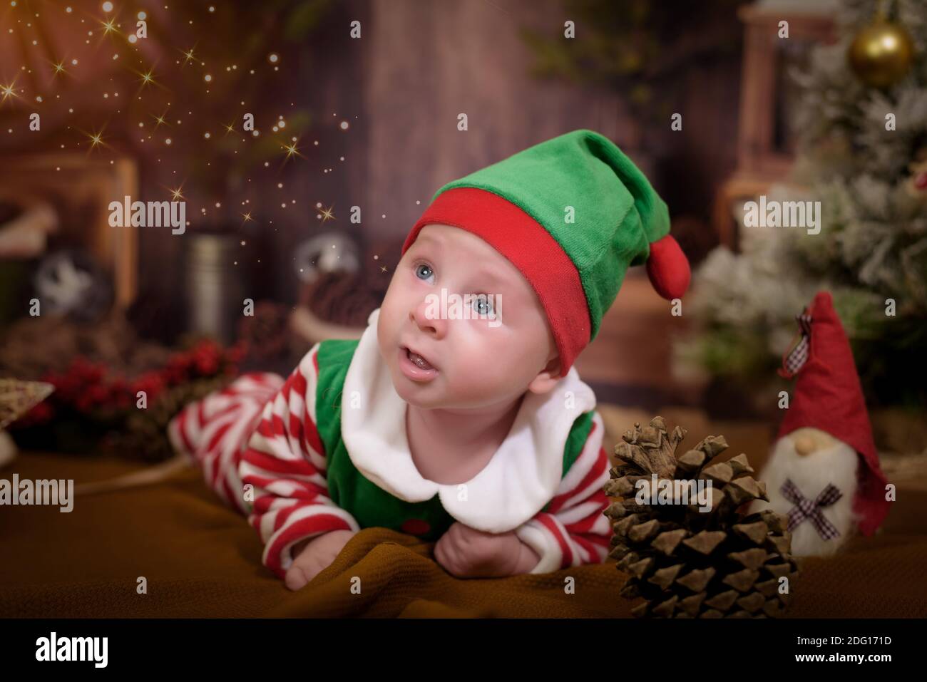 Happy baby elf helper of Santa in costume Santa Claus with gift at ...