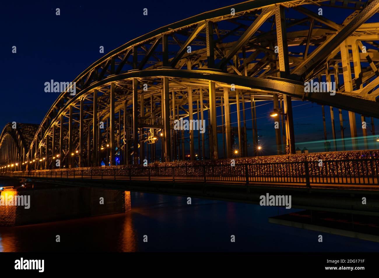 An illuminated Hohenzollern Arch Bridge details in Cologne, Germany at ...