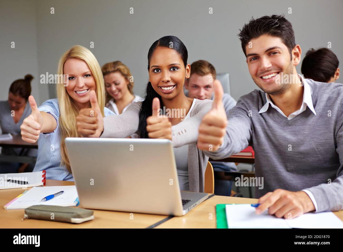 Students hold thumbs up Stock Photo - Alamy