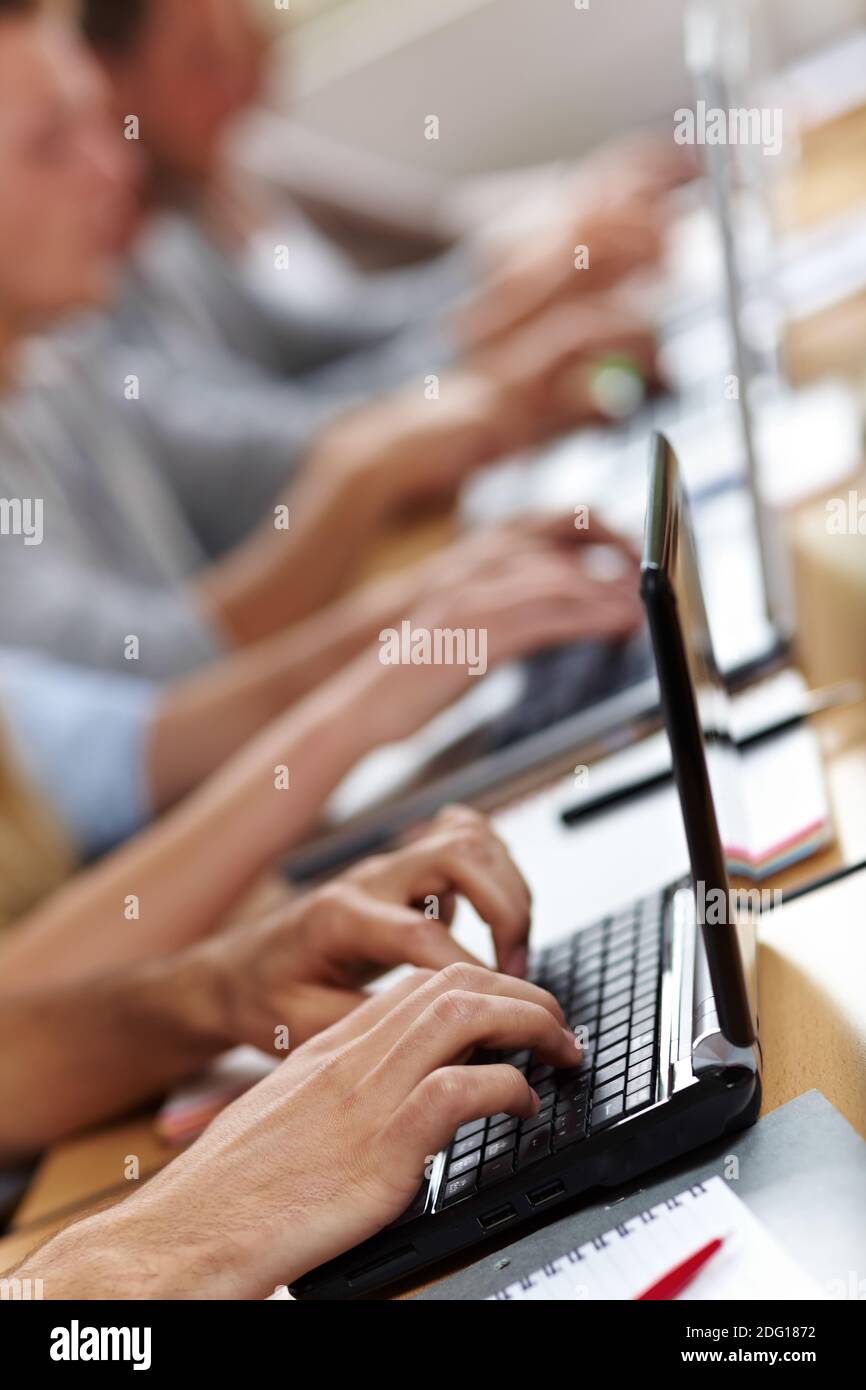 Many hands on laptops Stock Photo - Alamy