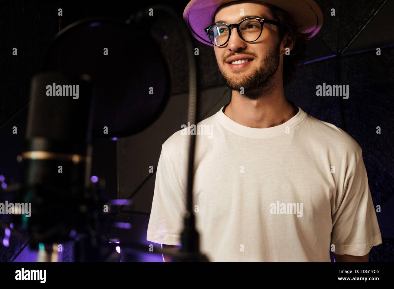 Attractive stylish male singer recording song for new music album in ...