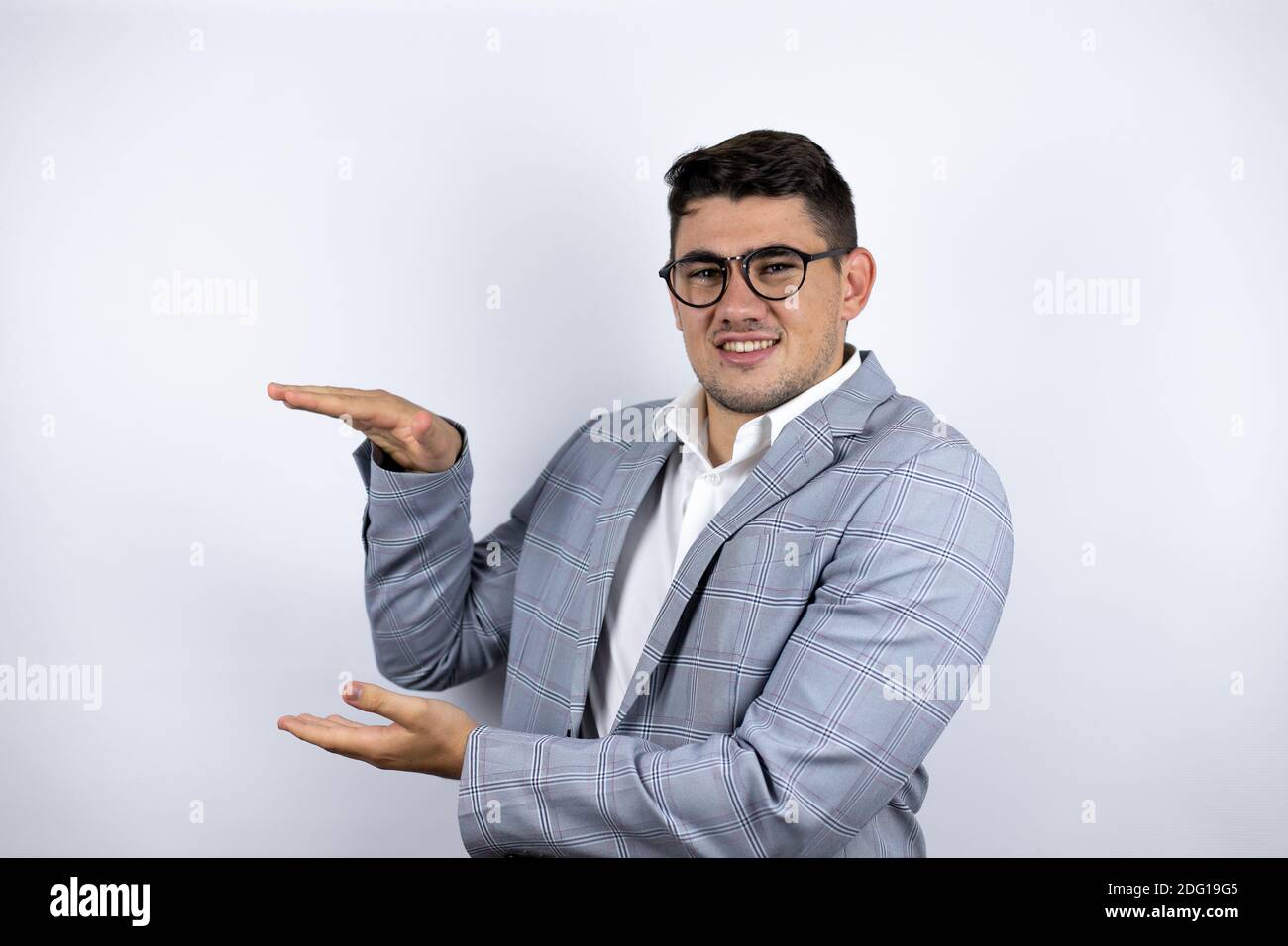 Business young man wearing suit over white background gesturing with ...