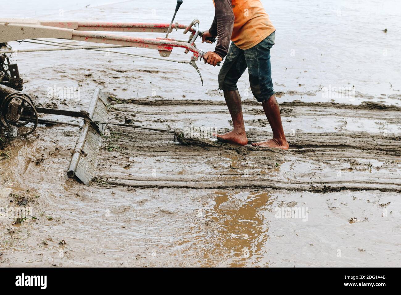 Indonesia Farmer plowing a rice field using tiller tractor Stock Photo ...