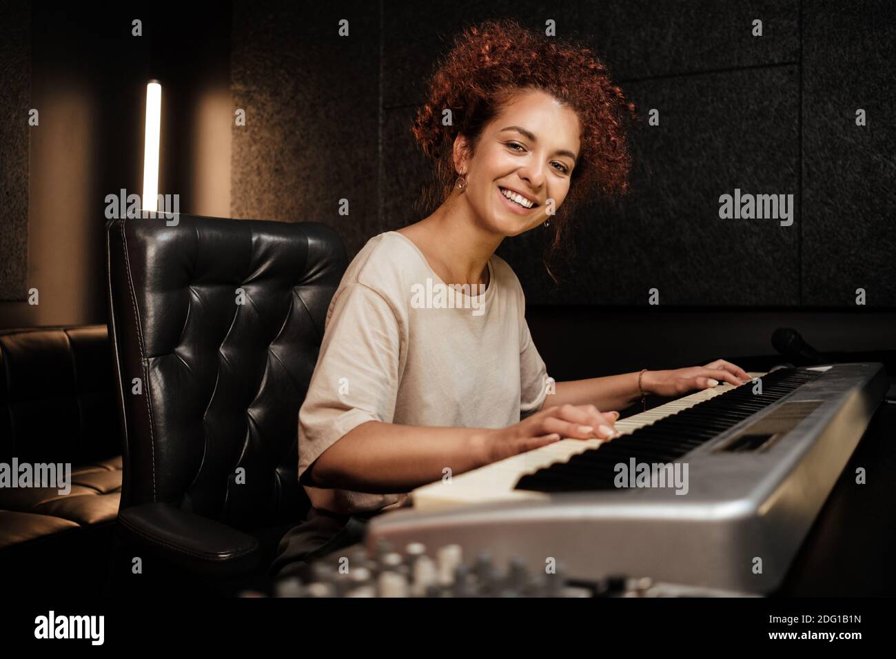 Young attractive woman happily looking in camera playing on electric ...