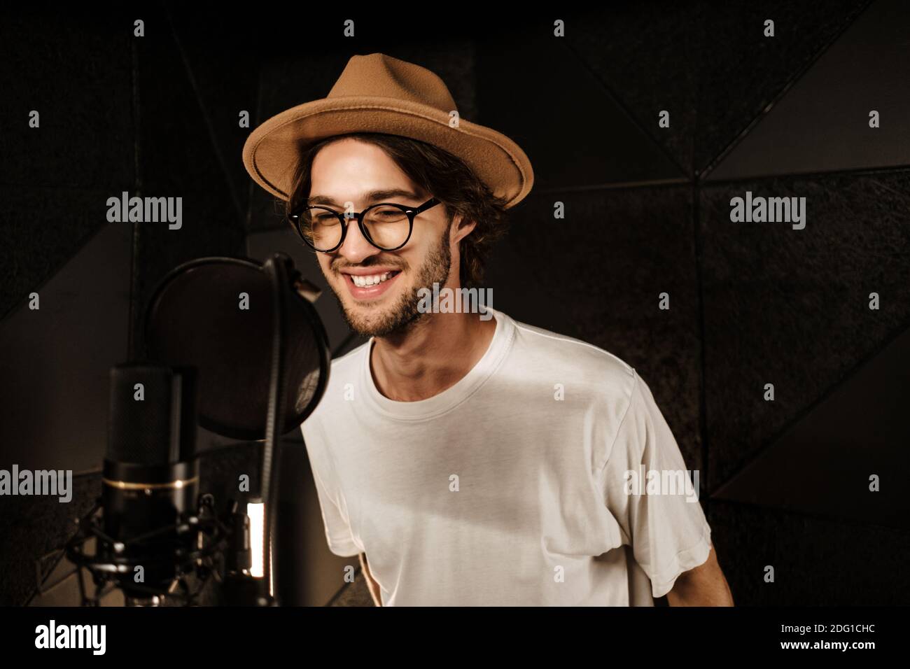 Handsome smiling male singer happily singing recording new song for ...