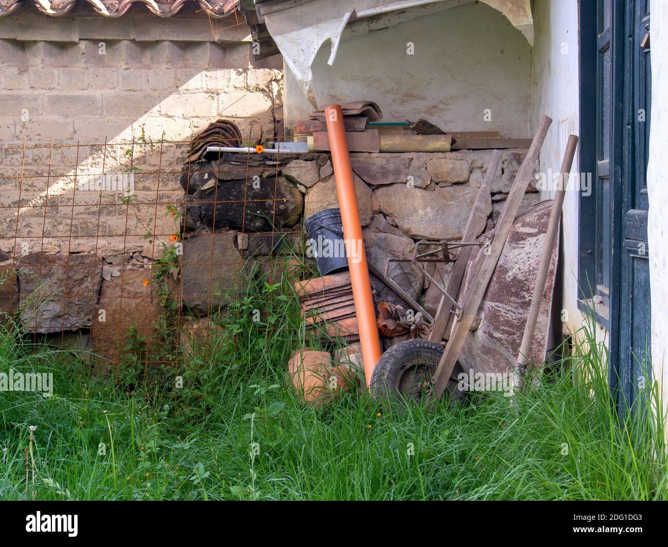 A messy corner in a garden, with an old wheelbarrow, in a house near ...