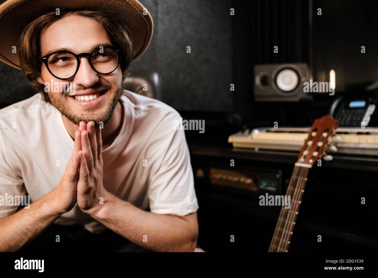 Portrait of attractive smiling singer man happily creating music in ...