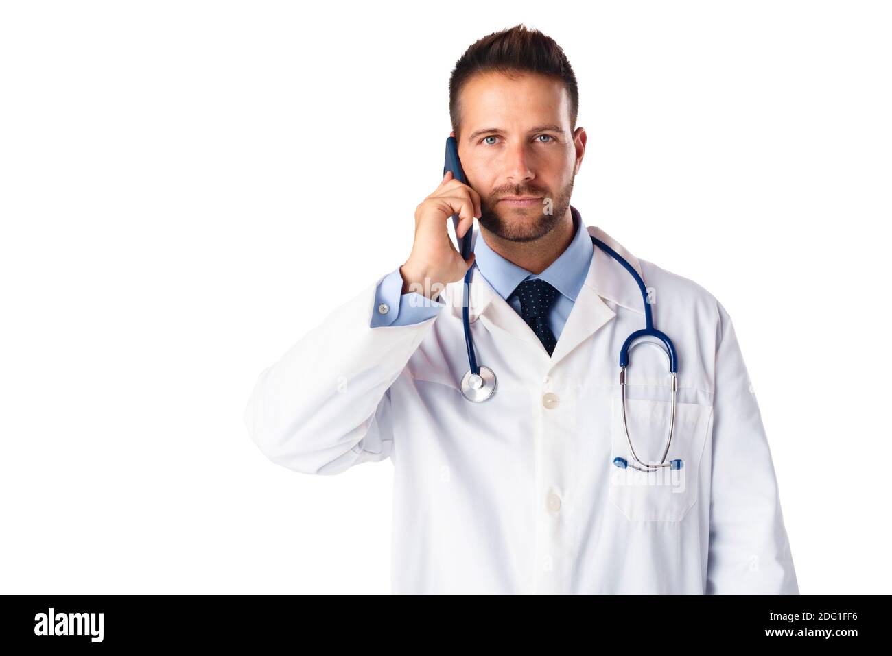 Studio shot of male doctor talking on his mobile phone while standing ...