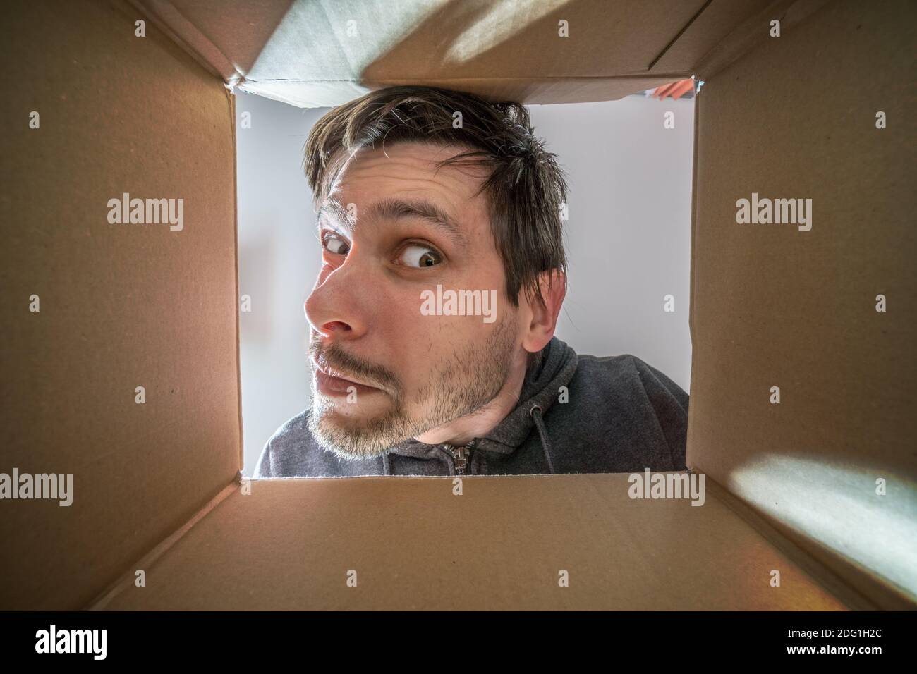 Young curious and suspicious man is looking inside cardboard box Stock ...