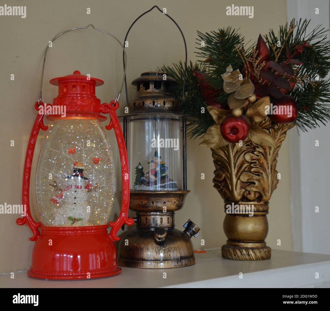 This is a photo of some Christmas Decor. There are two lanterns and one ...