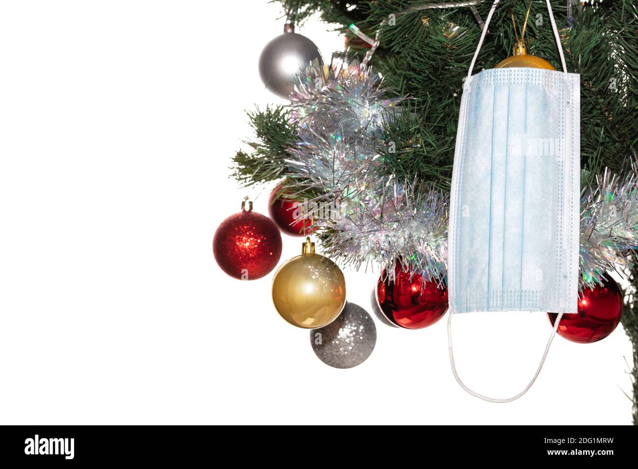 Christmas tree decorated with face mask, colorful balls, and tinsel ...