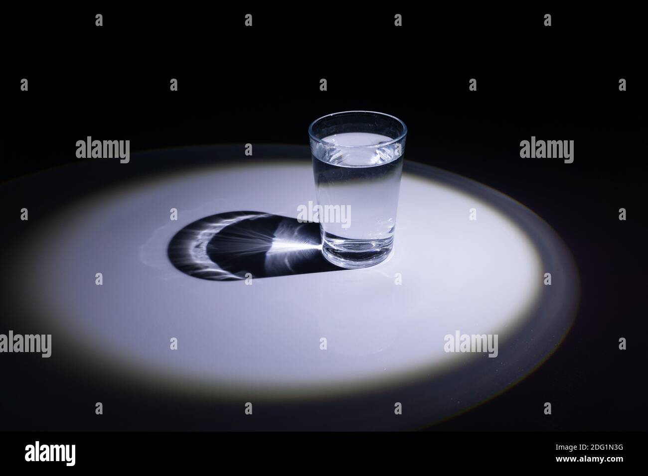 a glass of water and its reflection in the light Stock Photo - Alamy