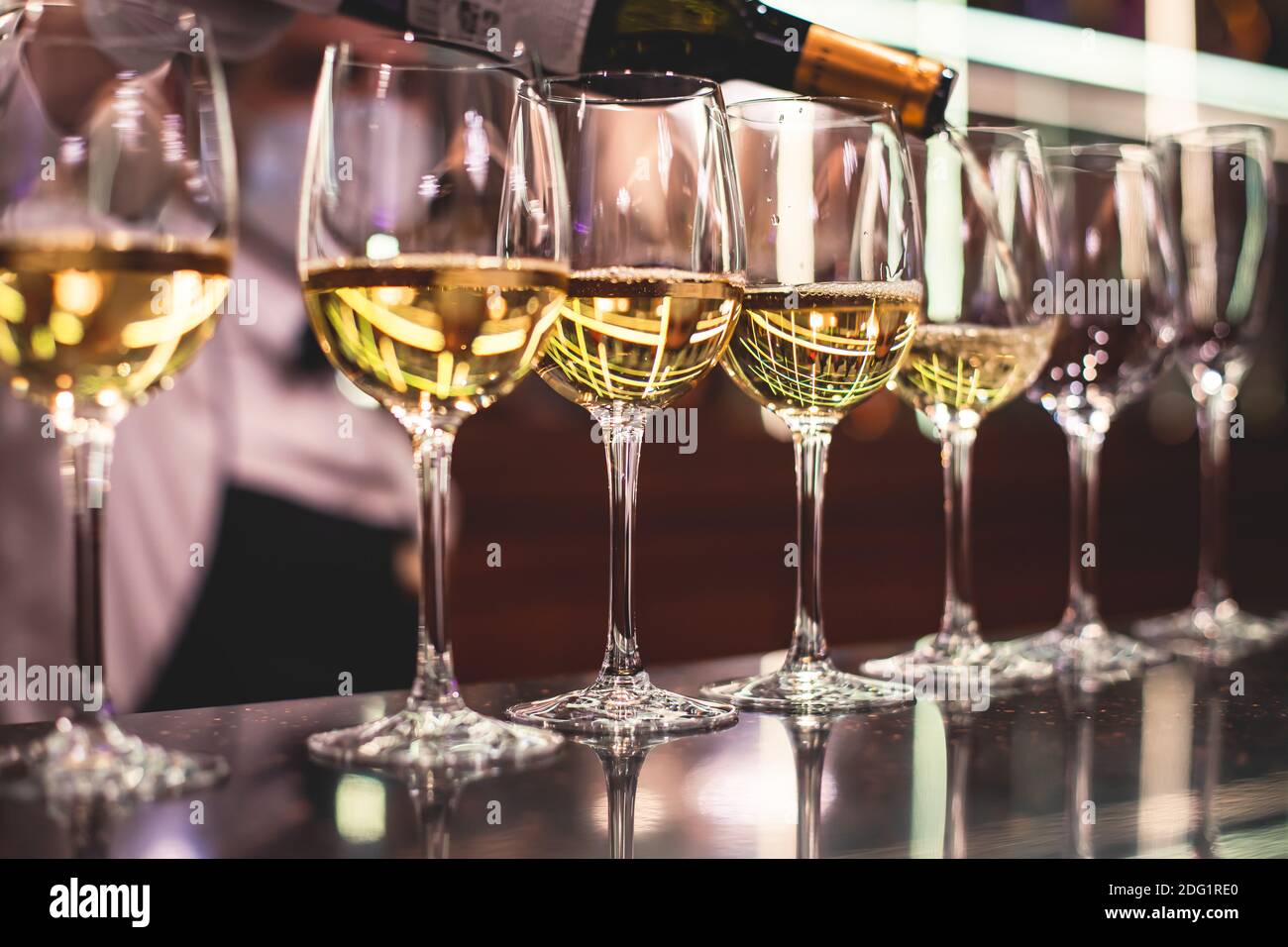 Line of alcohol setting on catering banquet table, bartender pouring ...