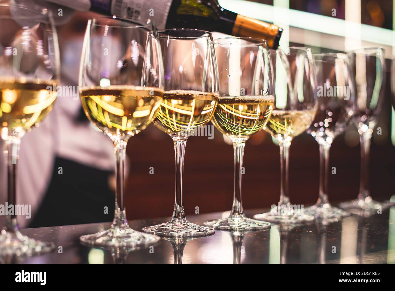 Line of alcohol setting on catering banquet table, bartender pouring ...