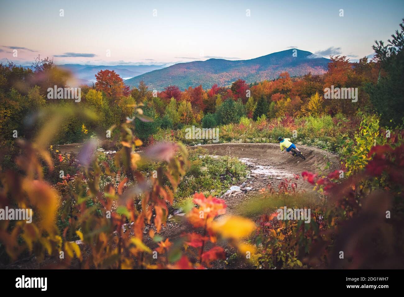 Male mountain-biking down berms during fall foliage season Stock Photo ...