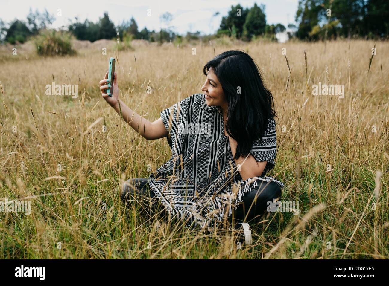 Portrait of a cute hispanic woman in the park making a selfie Stock ...
