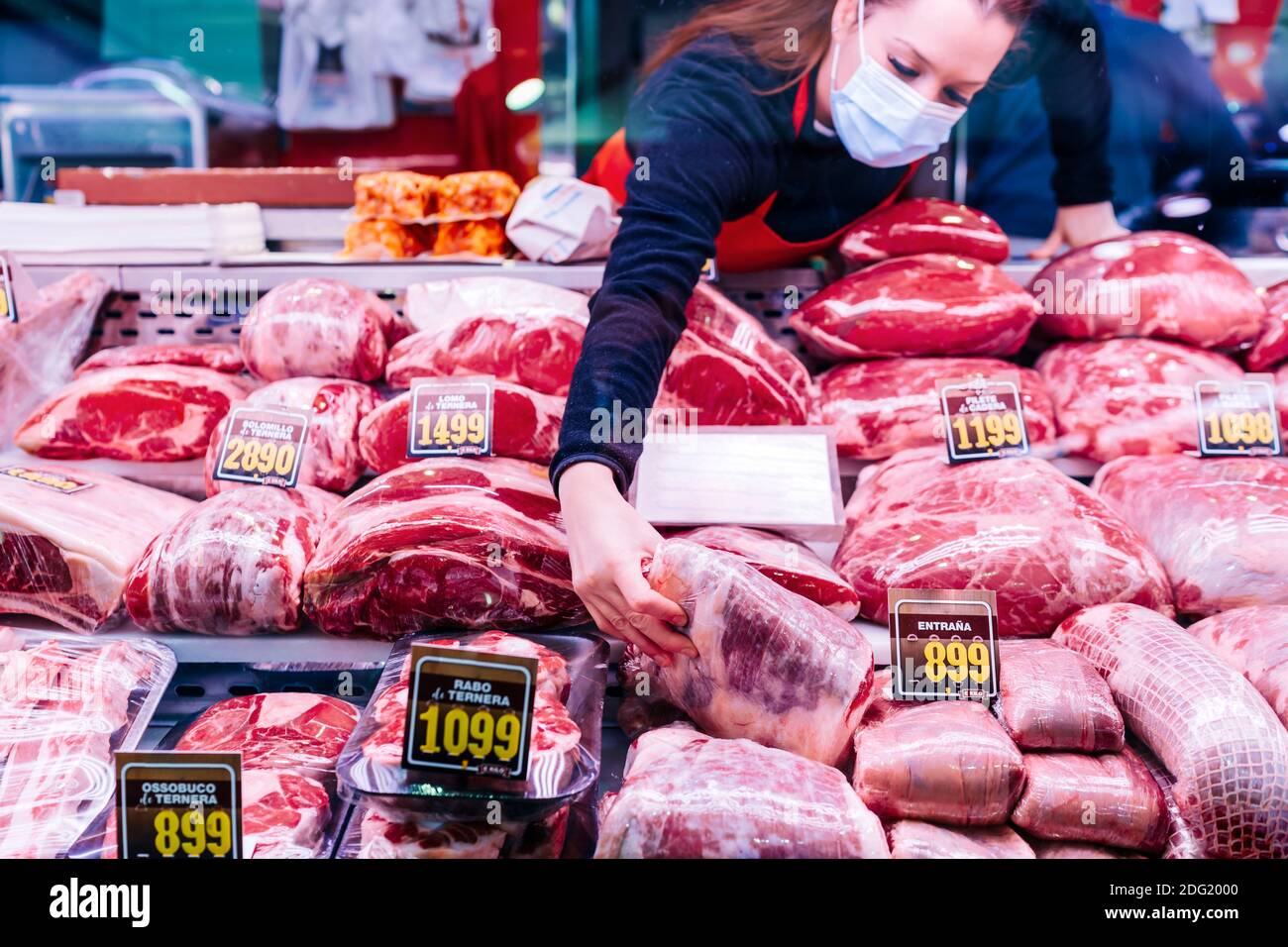 butcher woman choosing meat from the counter Stock Photo - Alamy