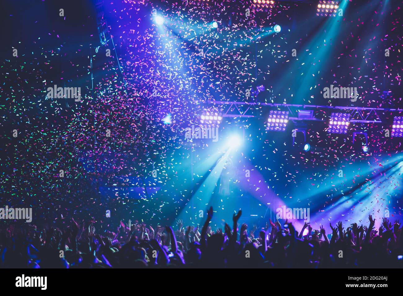 A crowded concert hall with scene stage lights, rock show performance ...