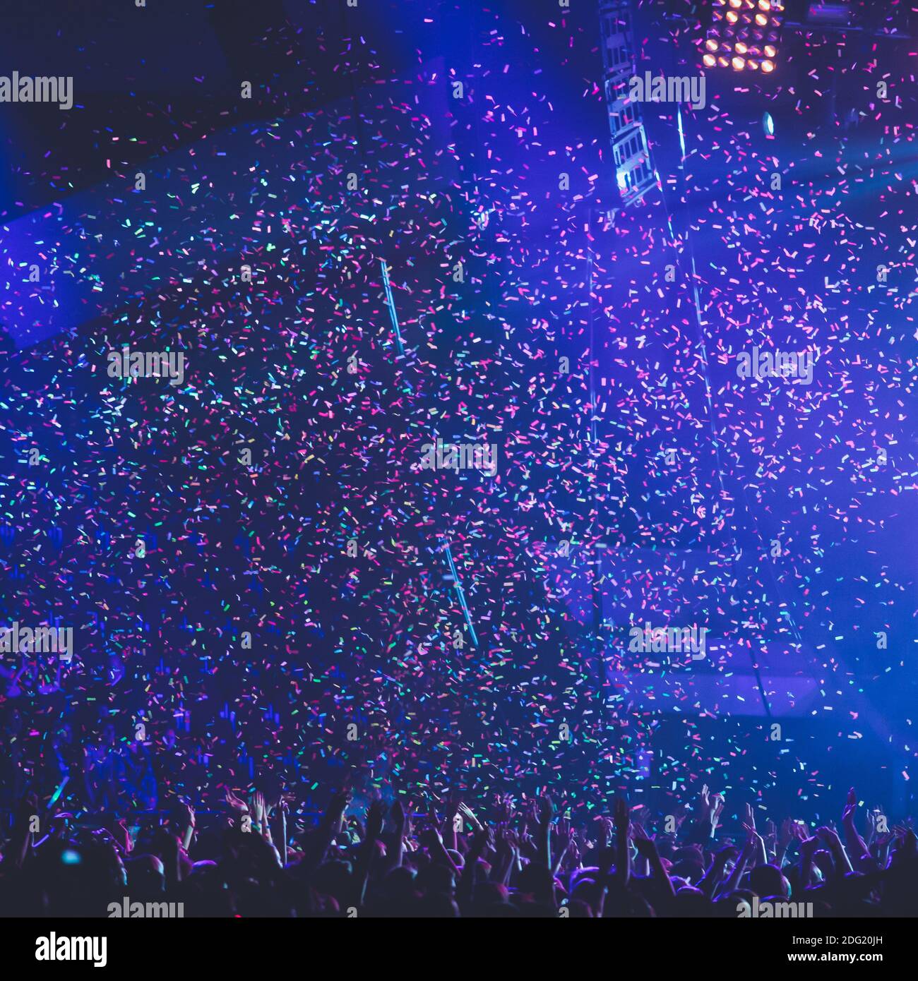 A crowded concert hall with scene stage lights, rock show performance ...