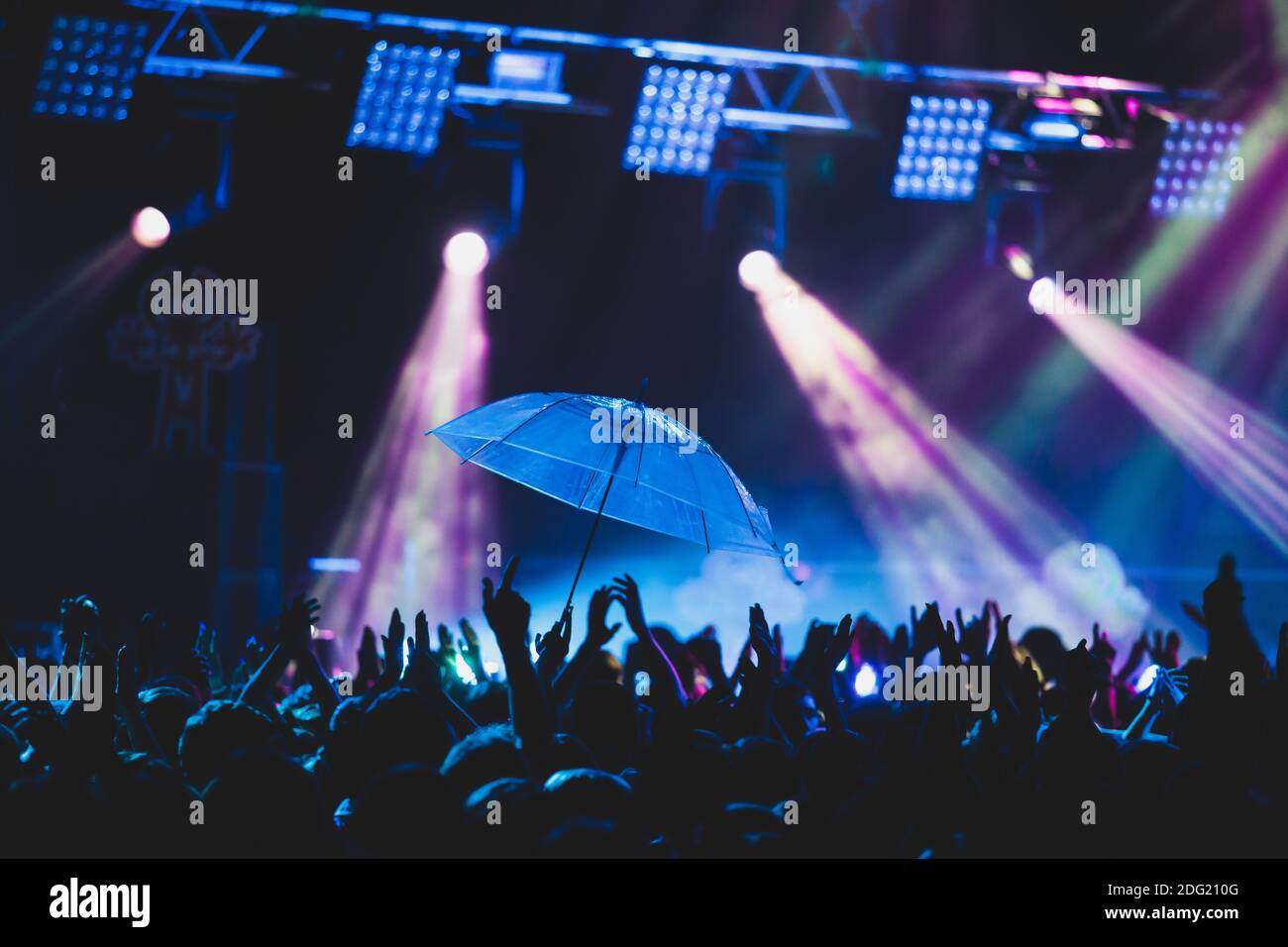 A crowded concert hall with scene stage lights, rock show performance ...