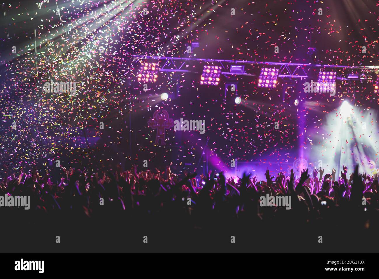 A crowded concert hall with scene stage lights, rock show performance ...
