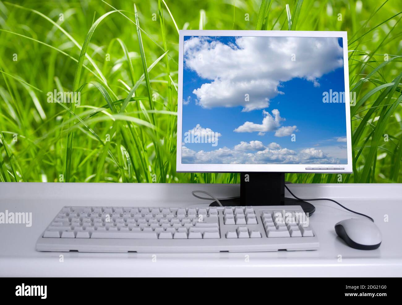 PC with green grass background and clouds on desktop Stock Photo - Alamy