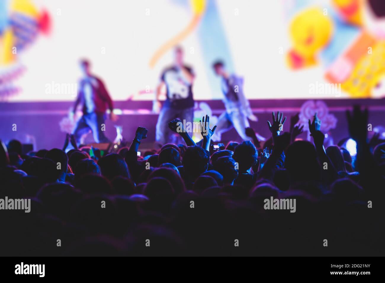 A crowded concert hall with scene stage lights, rock show performance ...