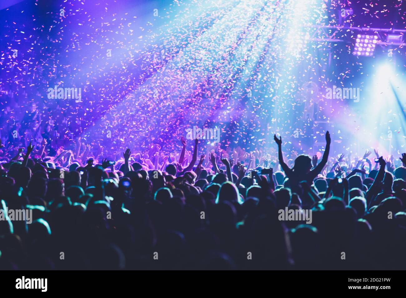 A crowded concert hall with scene stage lights, rock show performance ...