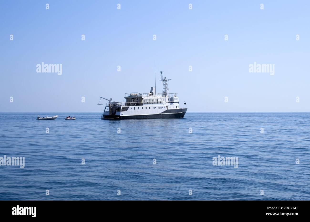 Ship and several boats going into the sea Stock Photo - Alamy