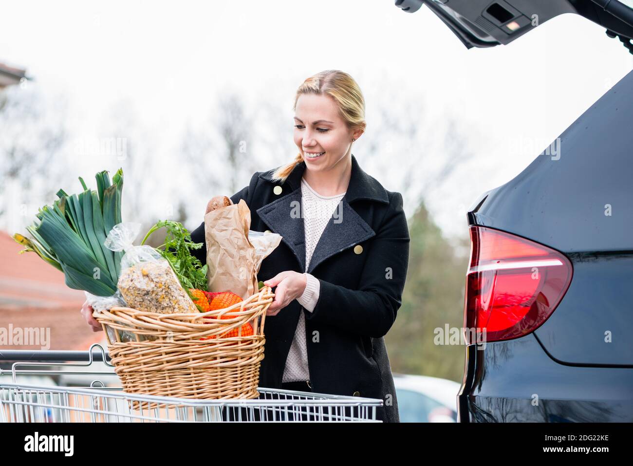 Woman loading groceries after shopping into trunk of her car Stock ...