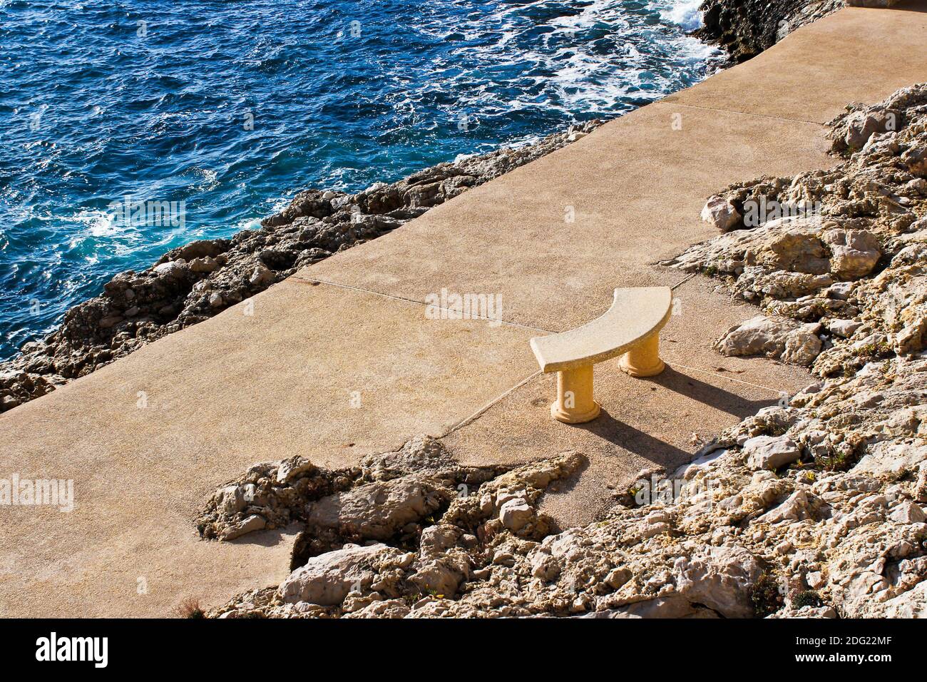 Beige Stone Bench At The Edge Of Bright Blue Rough Water Stock Photo ...