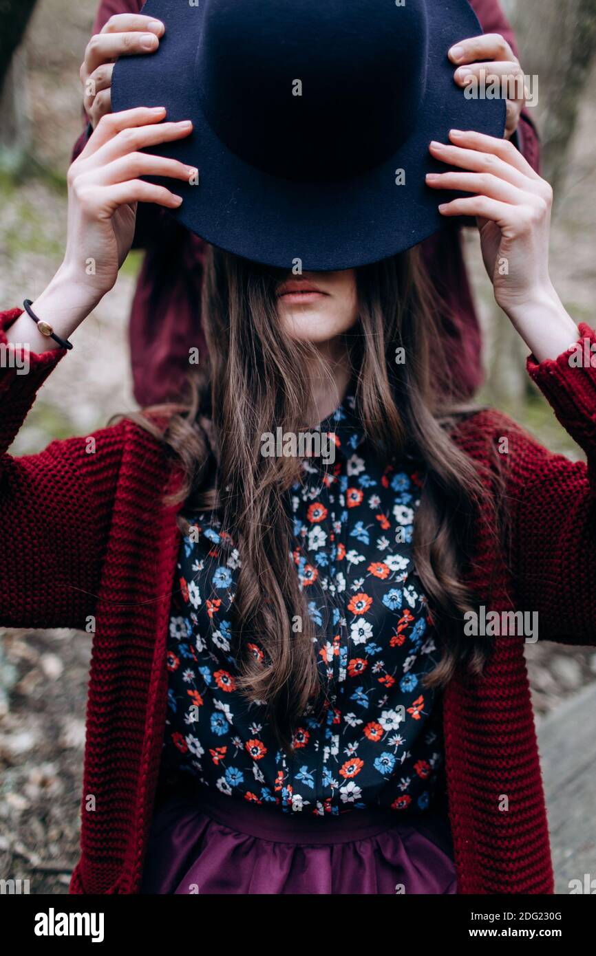 A girl with long hair covers her face with a hat. Harmony within you ...