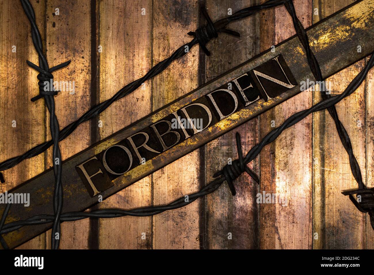Forbidden text over barbed wire on grunge bronze with textured copper ...