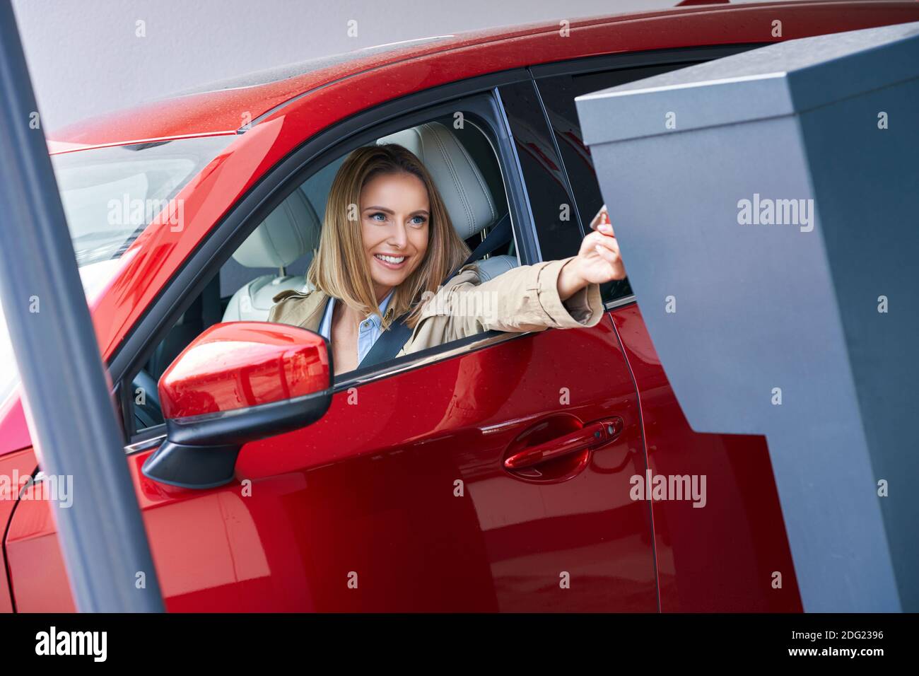 Woman getting ticket from parking meter in underground parking Stock ...