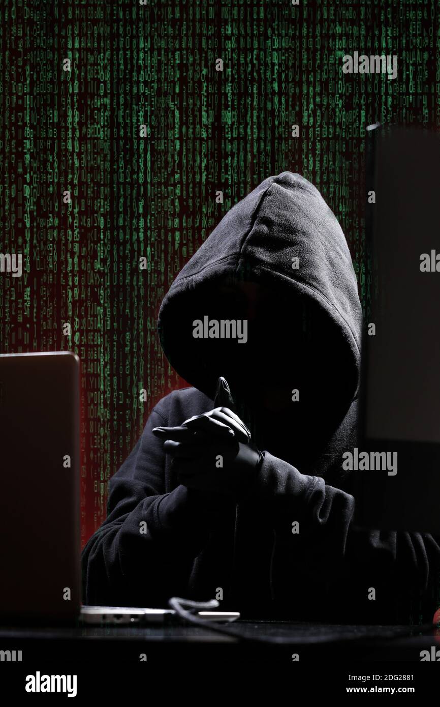 International hacker in black pullover and black mask trying to hack ...