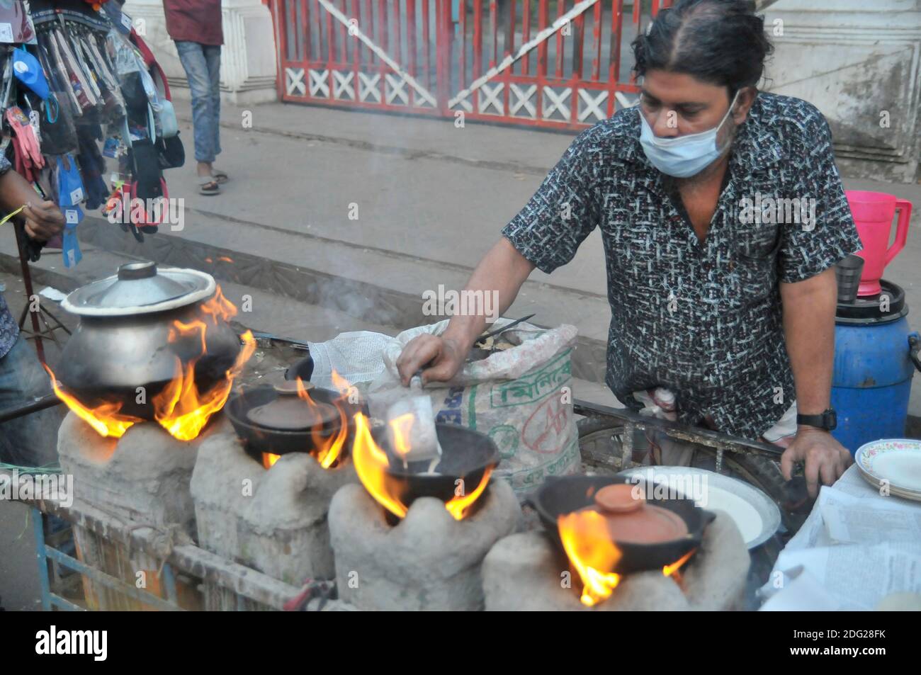 A cake vendor is making winter cakes on the street of Sylhet ...