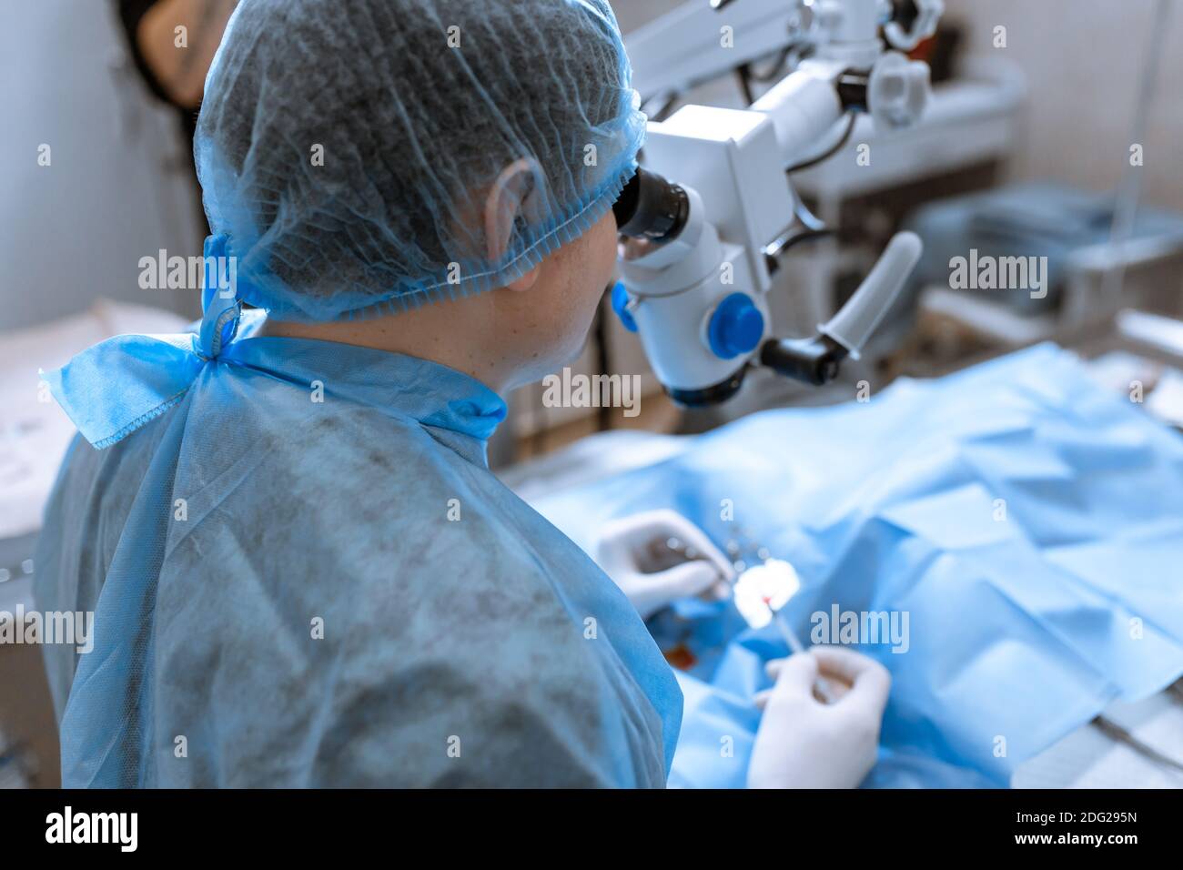 ophthalmologist surgeon looking through surgical microscope doing ...