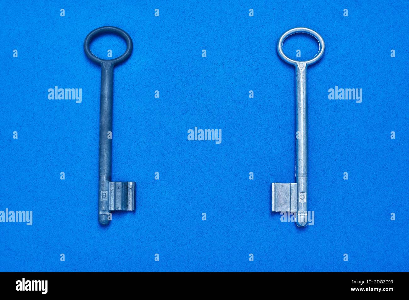 A top view of two metal keys on blue surface Stock Photo - Alamy