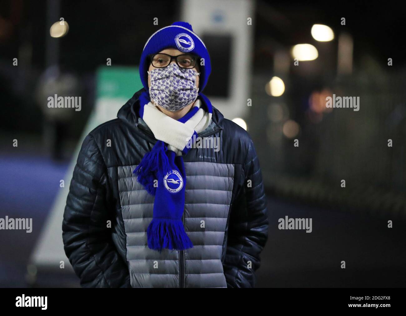 A Brighton and Hove Albion fan wearing a face mask arrives for the ...