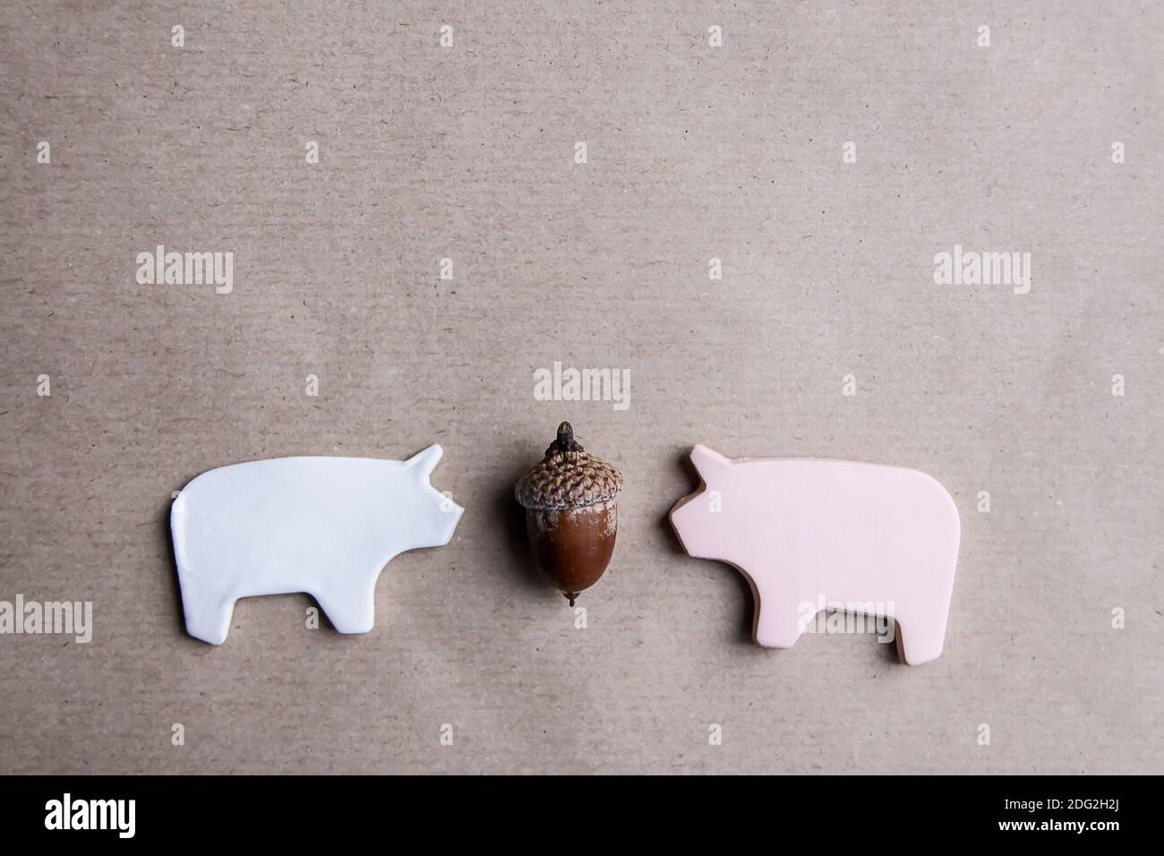 Two handmade clay pigs with acorn on craft paper background, Valentine ...