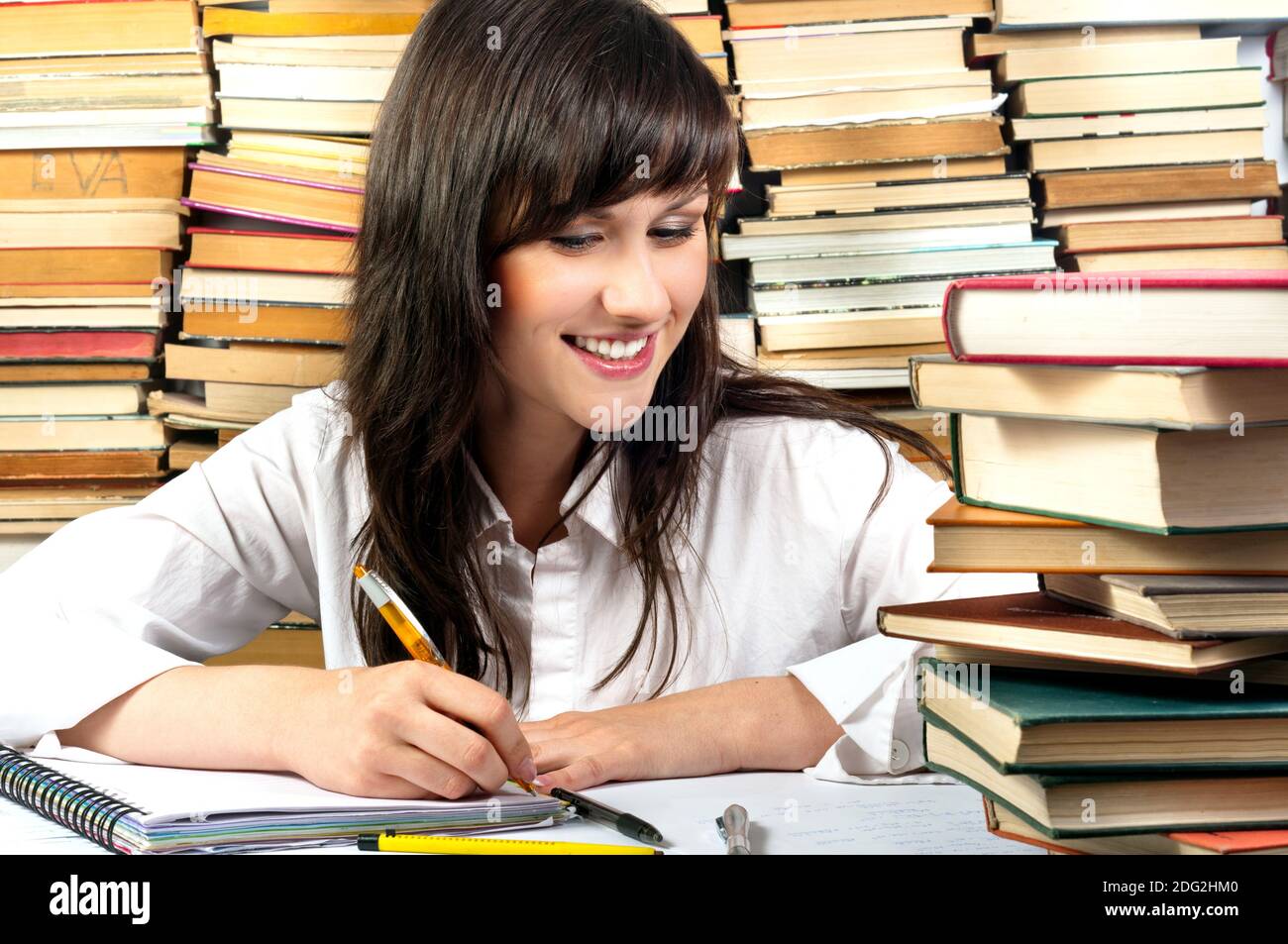 Attractive student girl writing her homework Stock Photo - Alamy