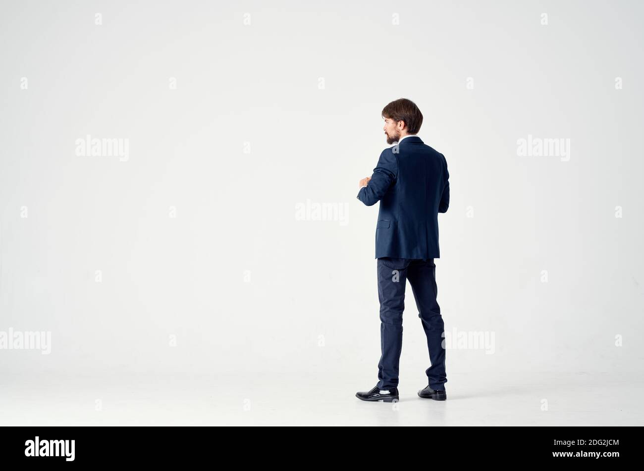 Gentleman in a blue suit gestures with his hands on a light background ...