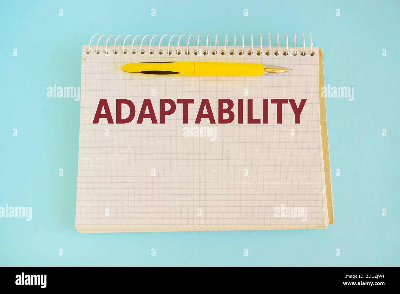 Hand writing the word Flexibility in notepad with yellow pen on blue ...