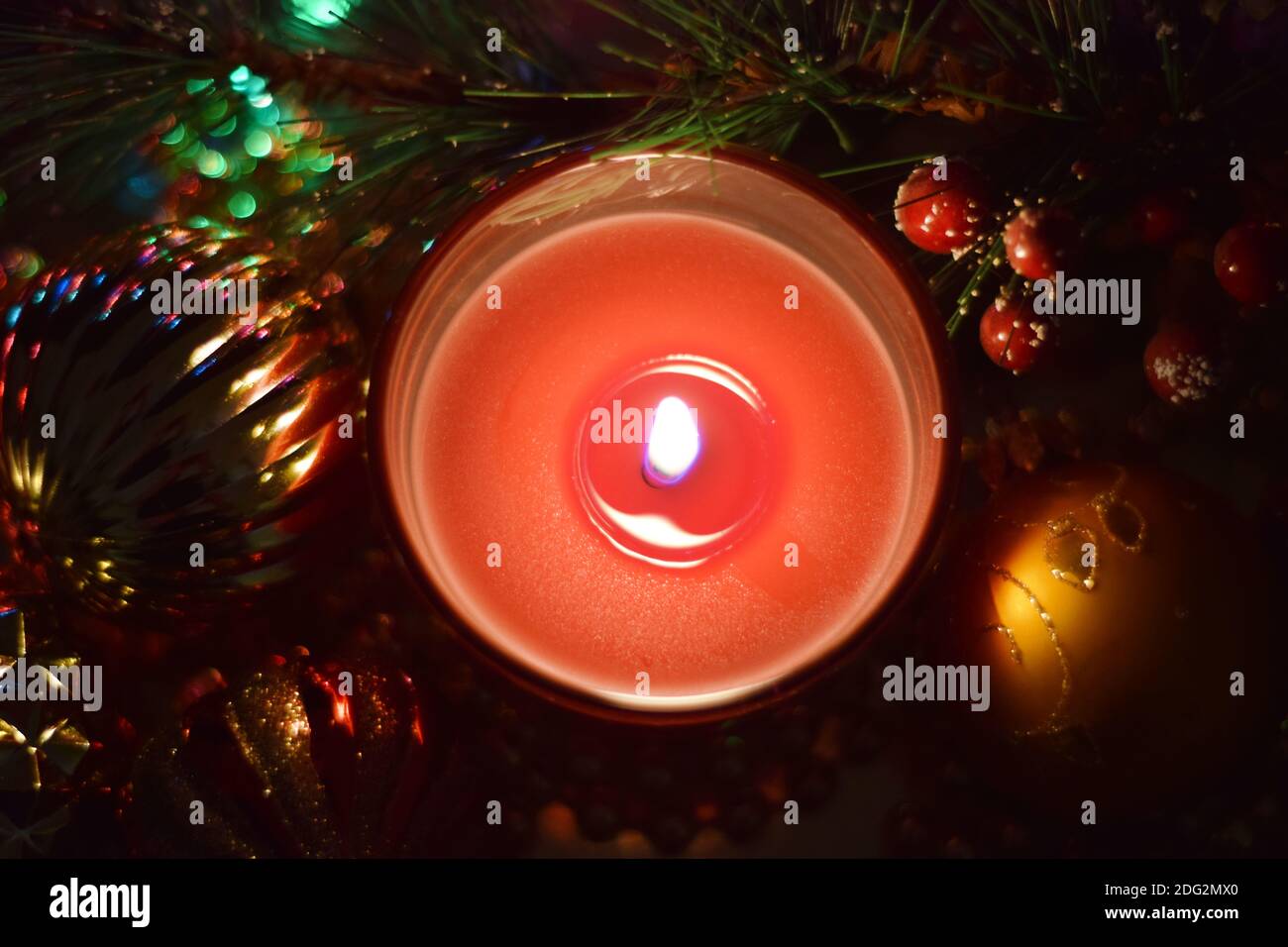 Lighted red candle in the dark with Christmas decorations Stock Photo ...
