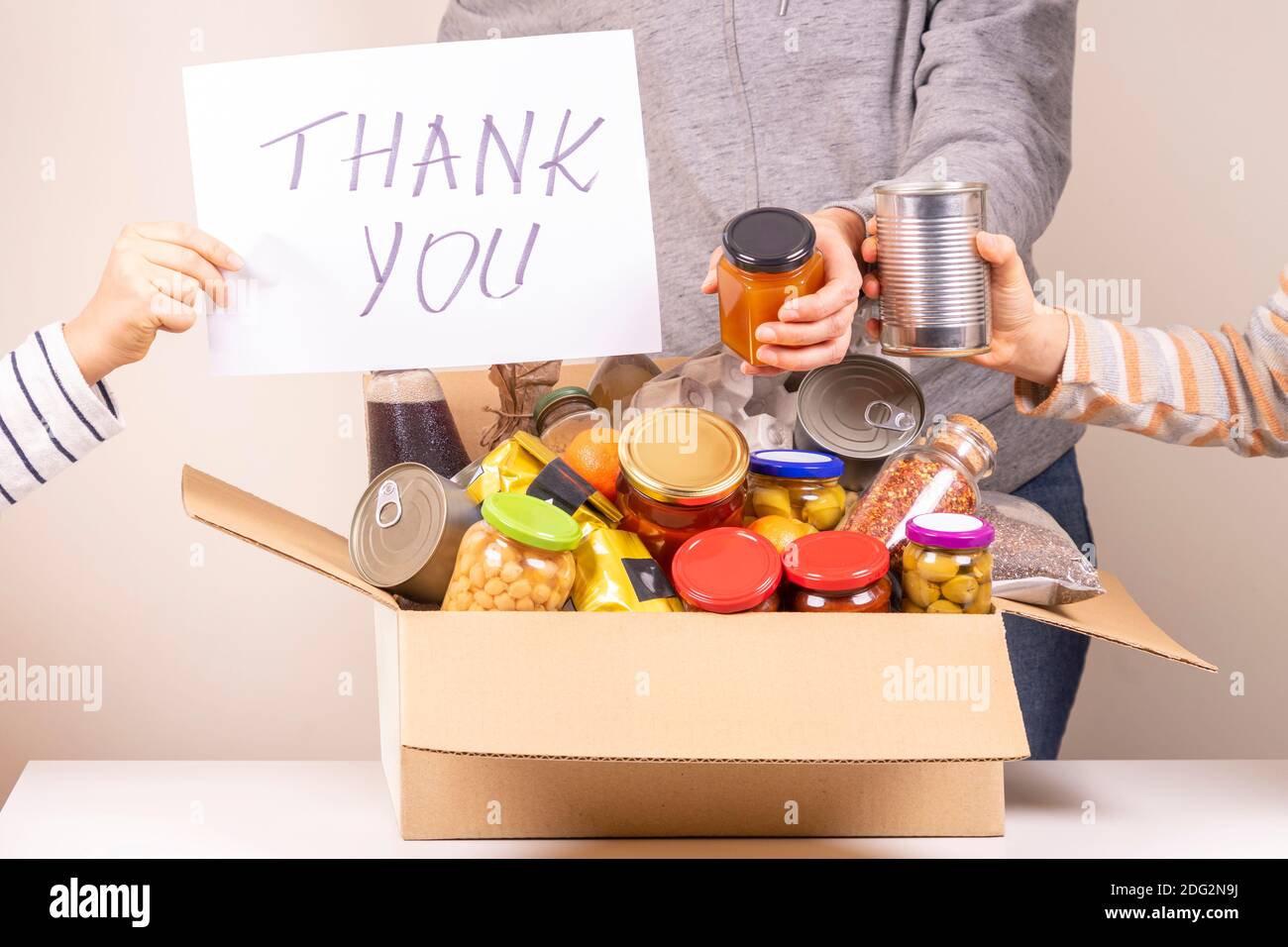 Volunteers collect grocery products to food donation box and holding ...
