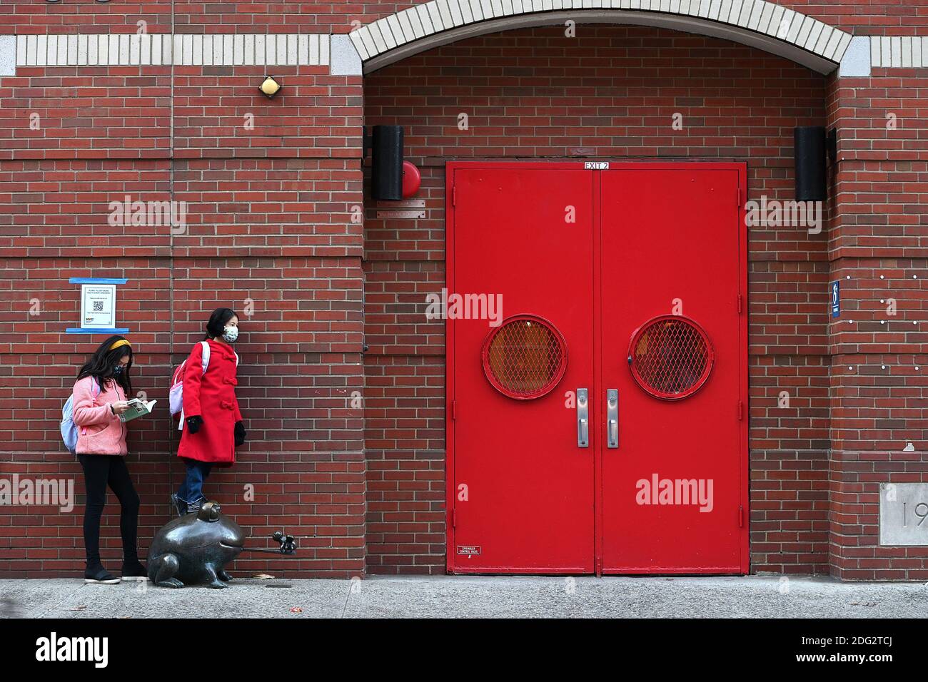 New York, USA. 07th Dec, 2020. Two students wait by the entrance of PS ...