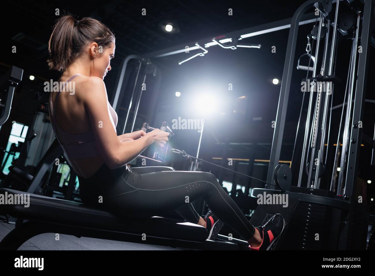 Young woman exercising rowing machine hi-res stock photography and ...
