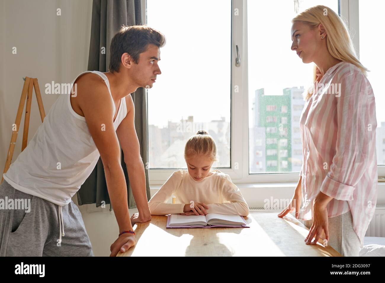 parents of child arguing while he is studying at home, sitting with ...